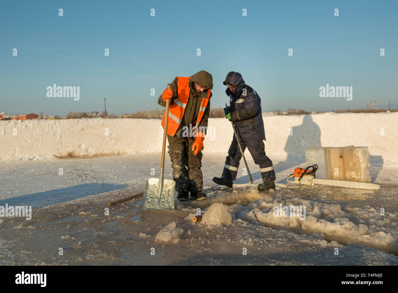Workers clean ice hole cut in the river of ice Stock Photo - Alamy