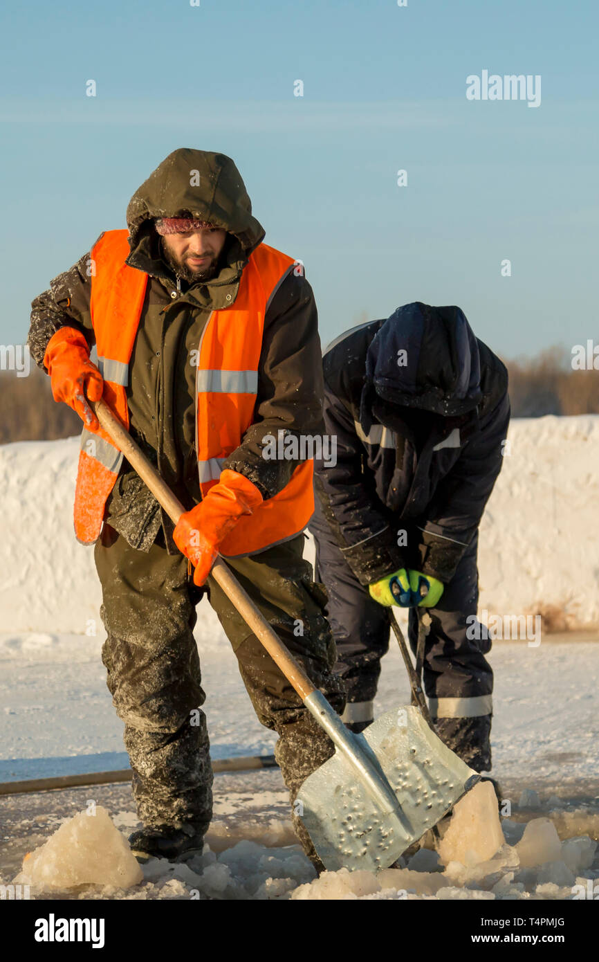 Workers clean ice hole cut in the river of ice Stock Photo - Alamy