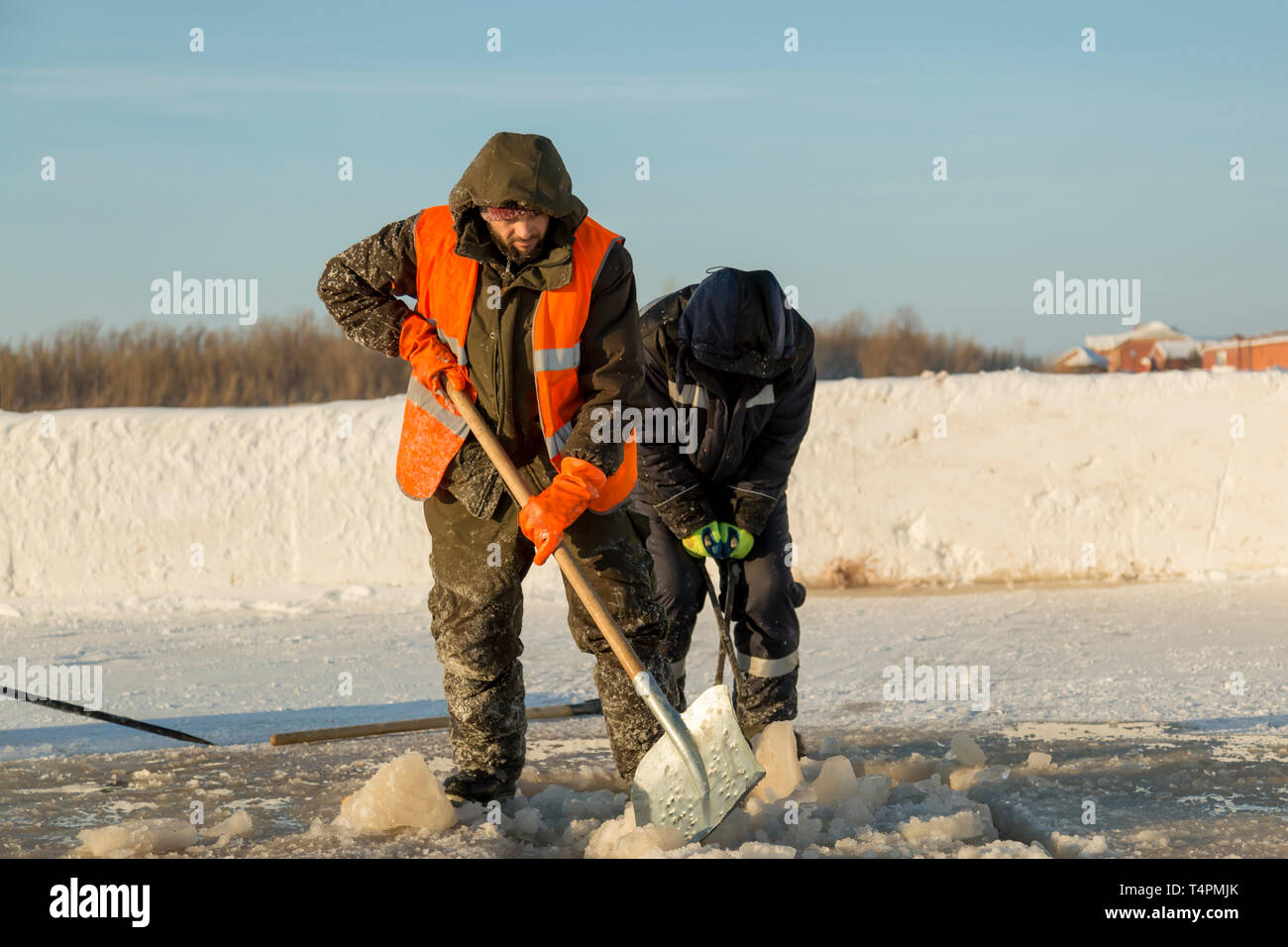 Workers clean ice hole cut in the river of ice Stock Photo - Alamy
