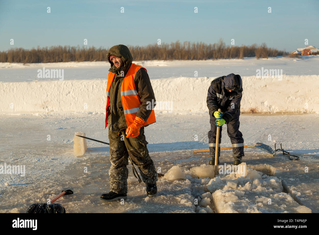 Workers clean ice hole cut in the river of ice Stock Photo - Alamy