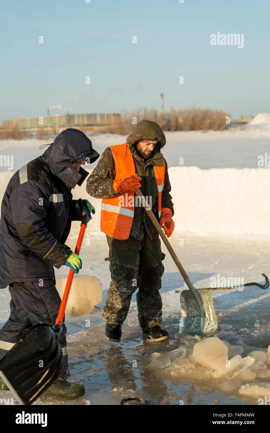 Workers clean ice hole cut in the river of ice Stock Photo - Alamy