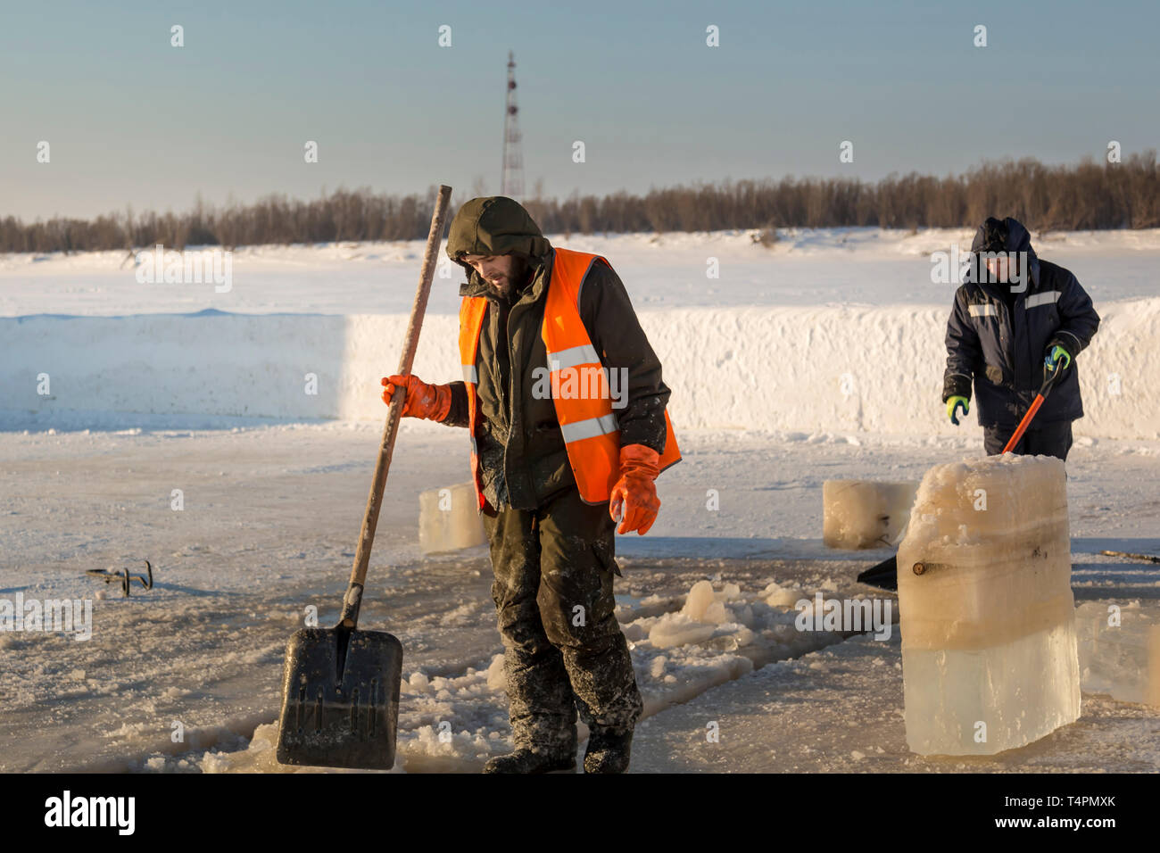 Workers clean ice hole cut in the river of ice Stock Photo - Alamy