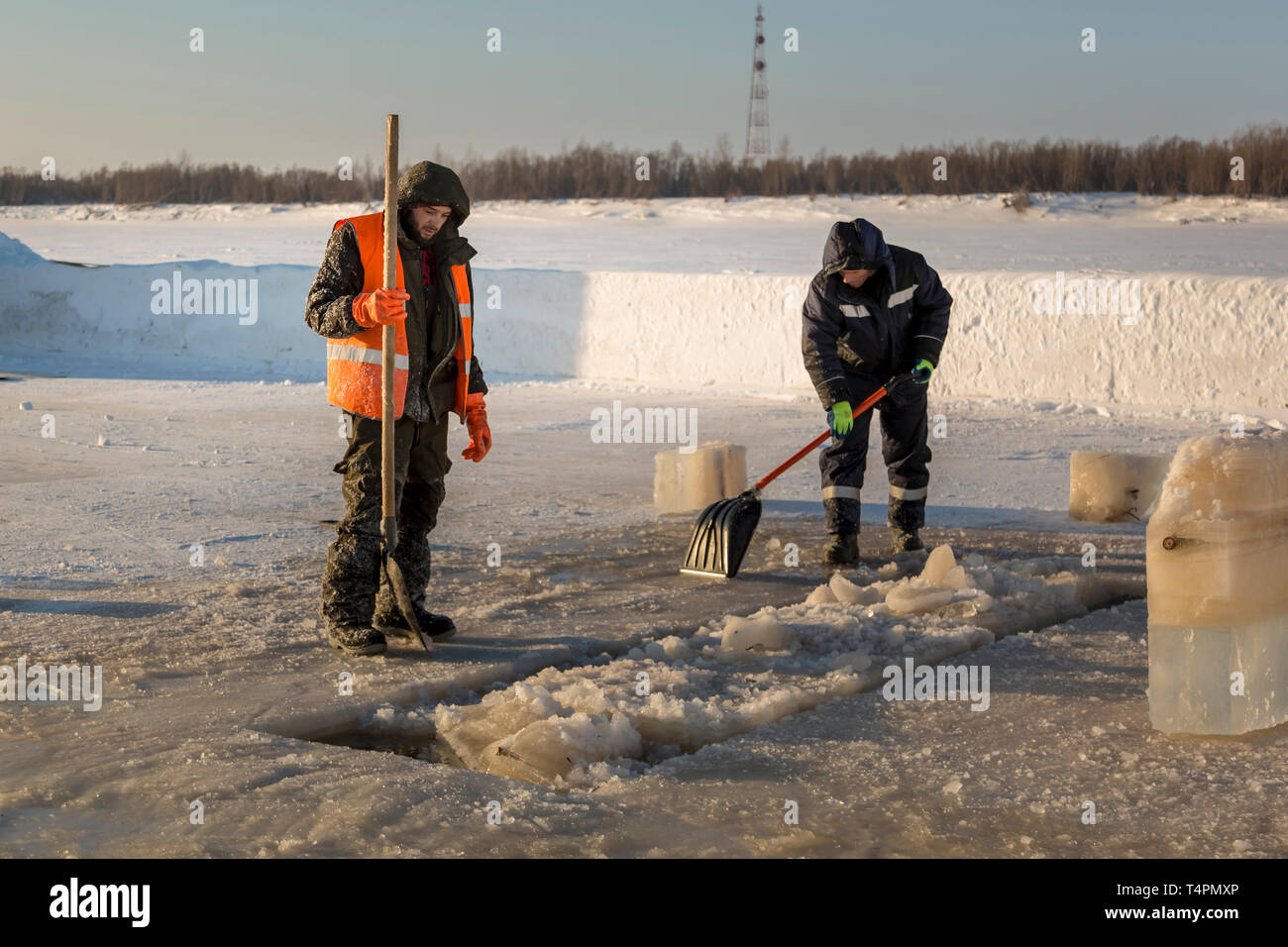 Workers clean ice hole cut in the river of ice Stock Photo - Alamy