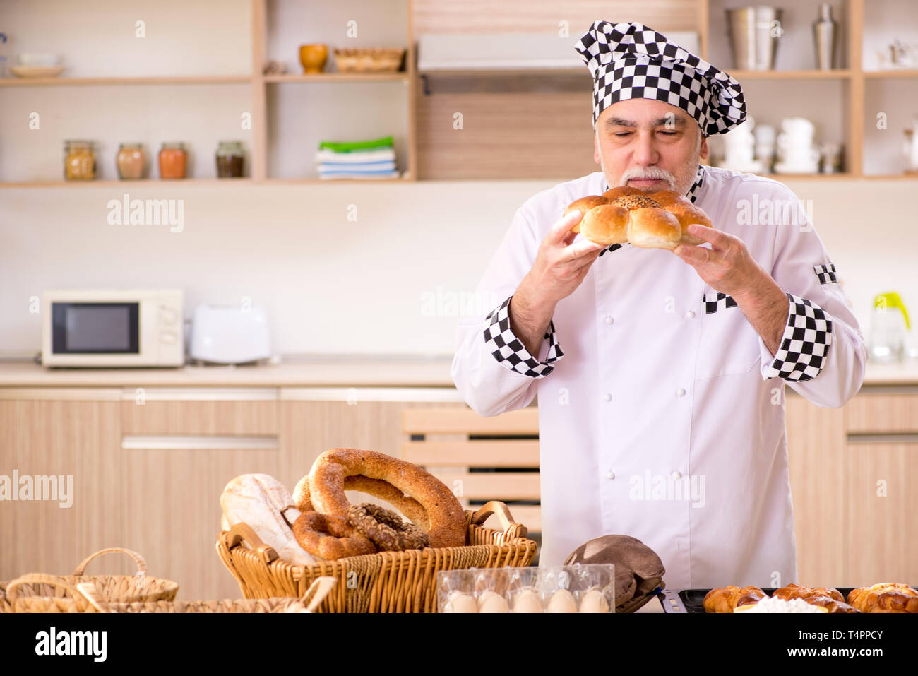 Old male baker working in the kitchen Stock Photo - Alamy