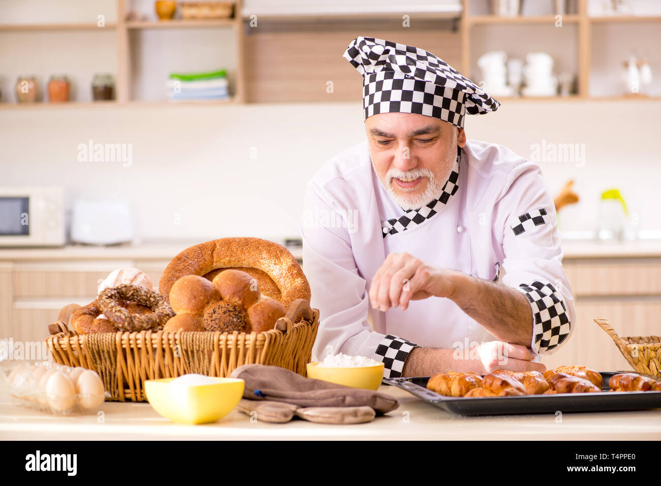 Old male baker working in the kitchen Stock Photo - Alamy
