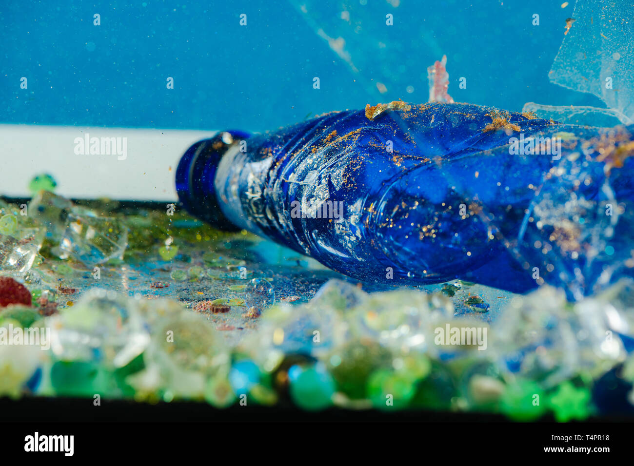 Transparent ruined plastic. Dirty blue crumpled bottle being covered ...