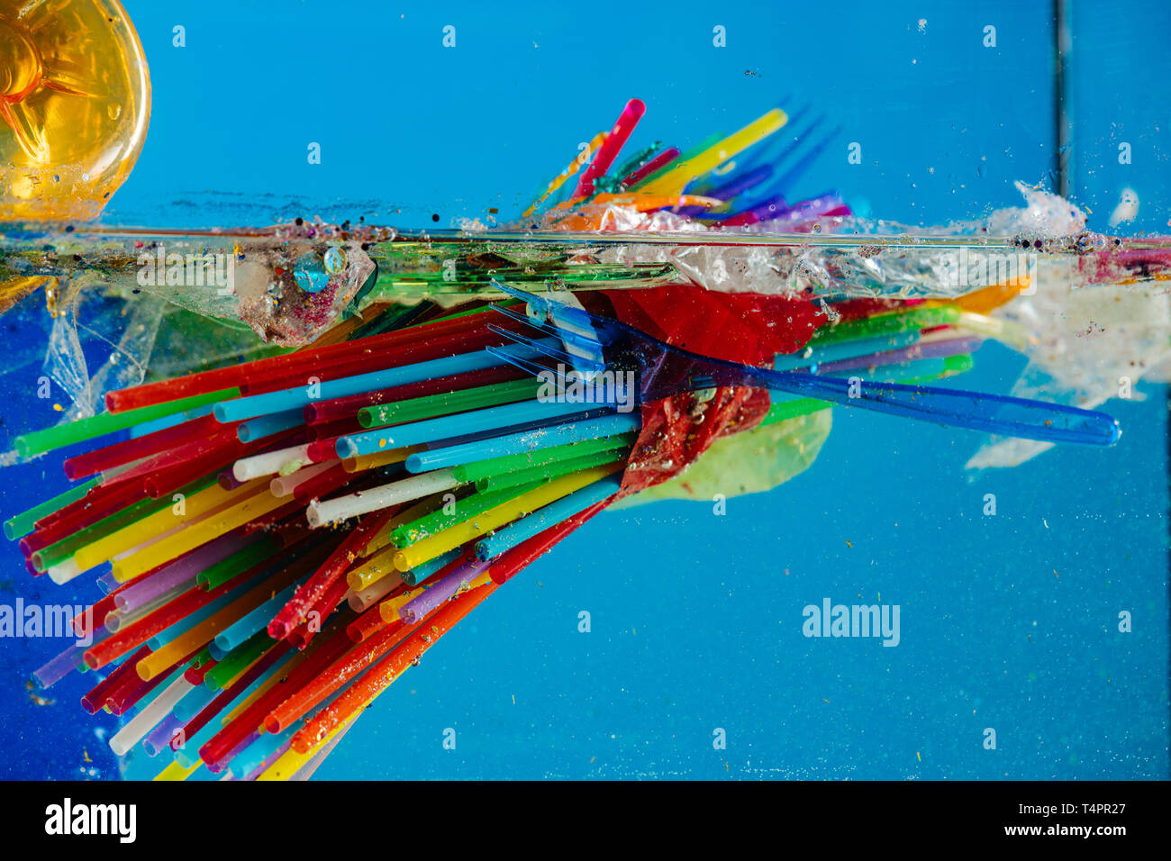 Floating with glitter. Plastic trash swimming on top of the water and ...