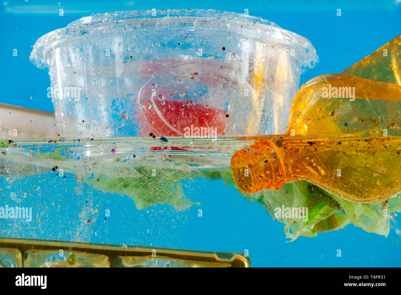 Crumpled used bag. Transparent food container floating on the water ...