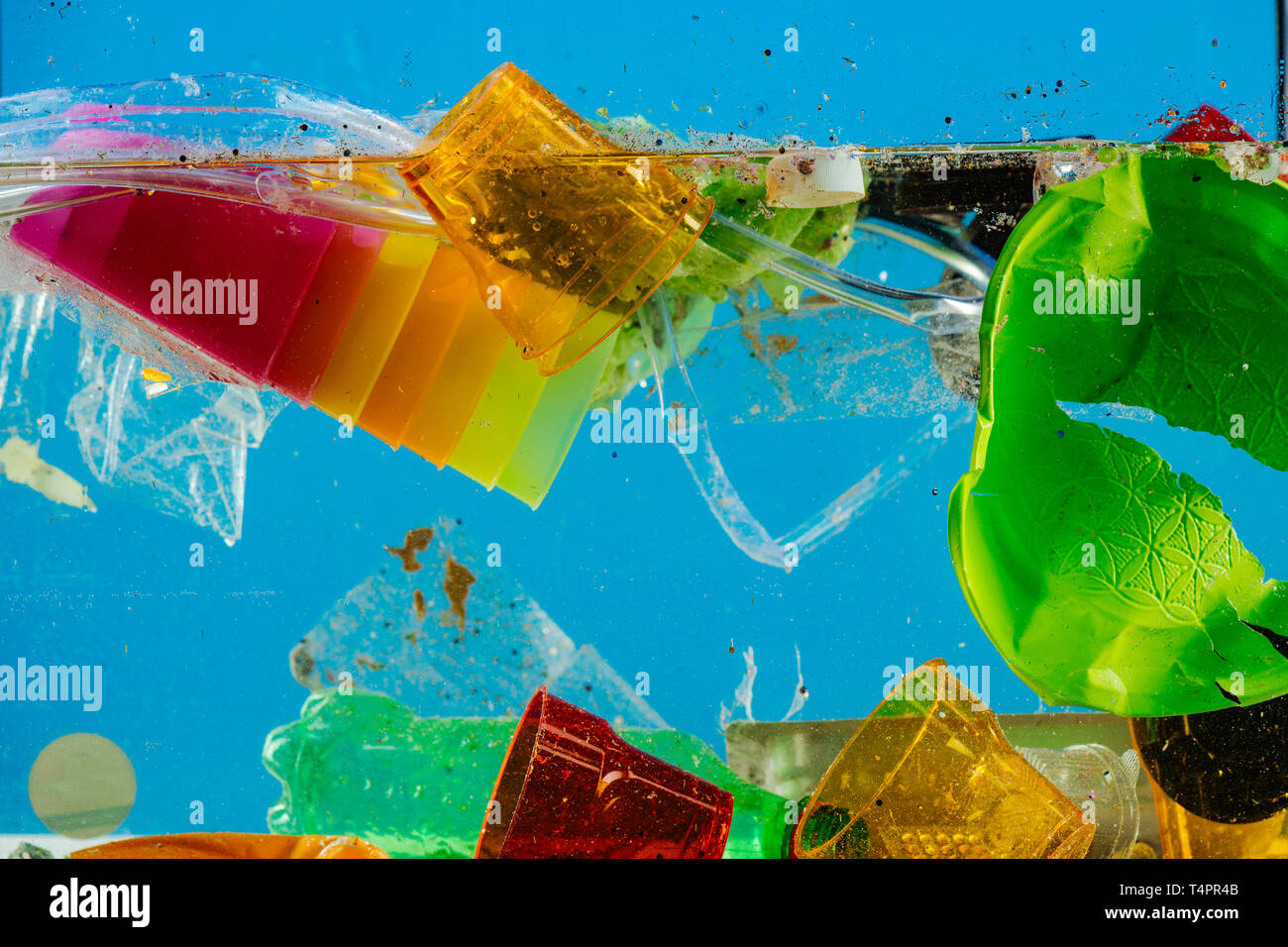 Red transparent cup. Broken colorful plastic mess floating in dirty ...