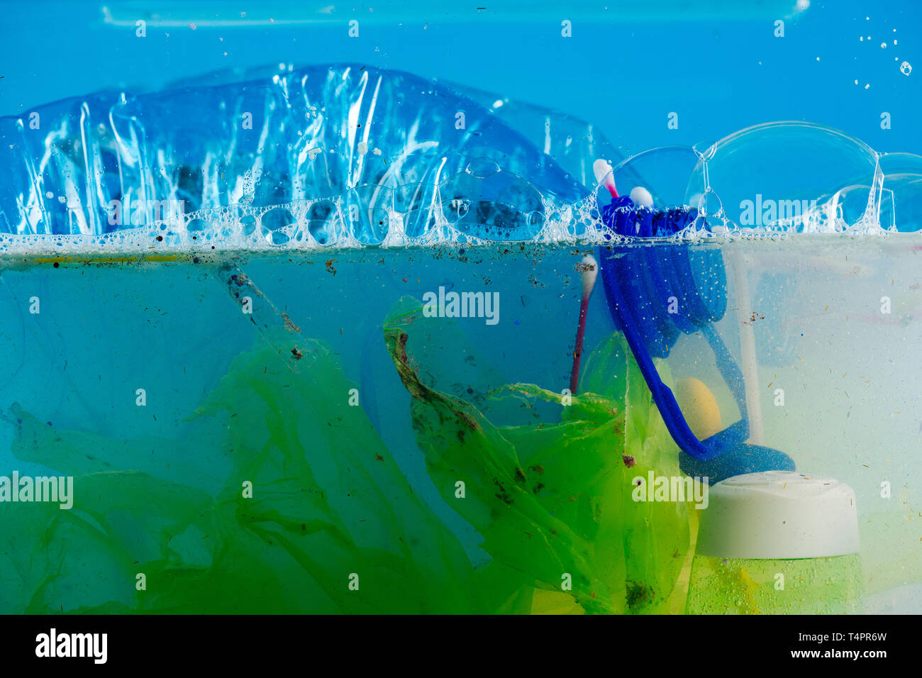 Pieces of trash . Big plastic water bottle being drawn into soapy muddy ...