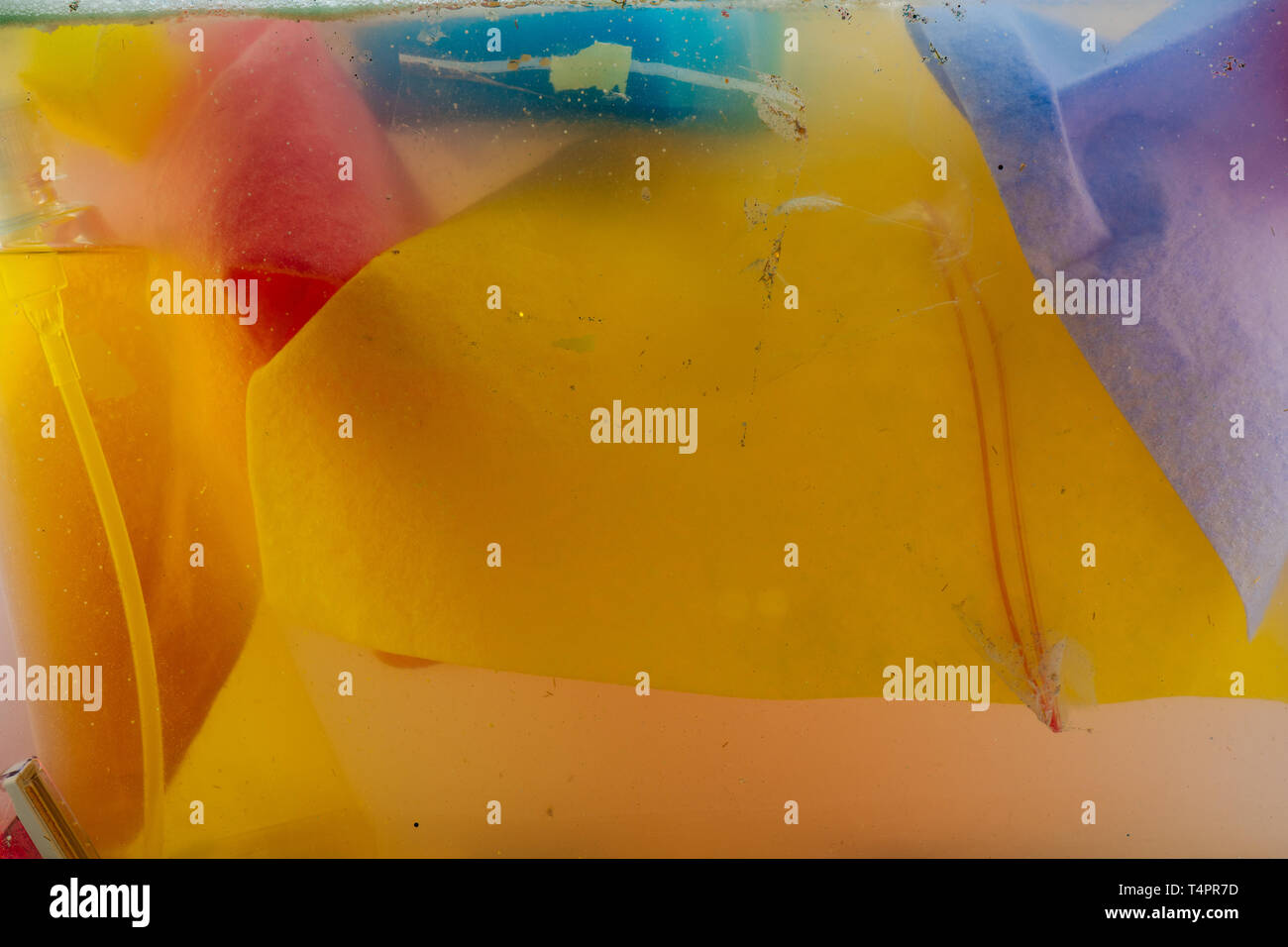 Soapy water. Colorful thrown rags and fabric placed into dirty water ...