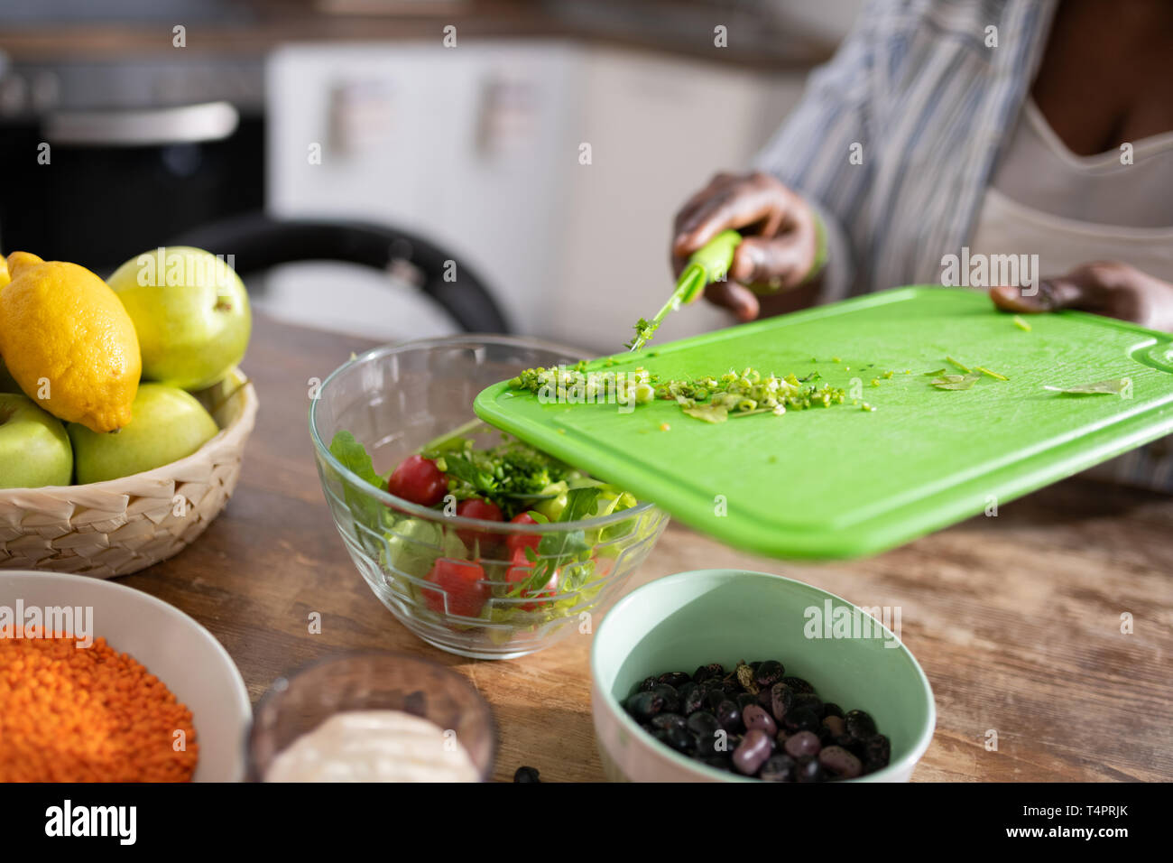 Working process. Busy housewife standing at the table and cooking ...