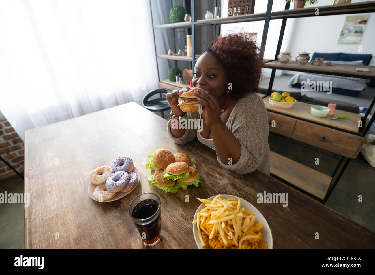 Feeling happiness. Pleased female person leaning elbows on table while ...