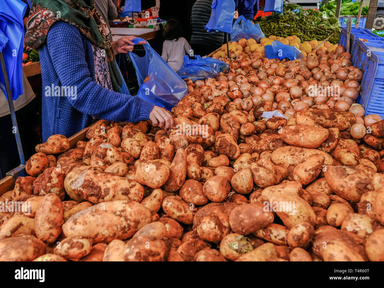Cyprus potatoes on sale at a market stall, Torso and hand of a lady ...