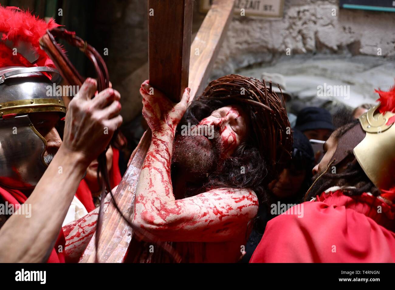 Jerusalem. 19th Apr, 2019. A worshipper holds a cross as he re-enacts ...