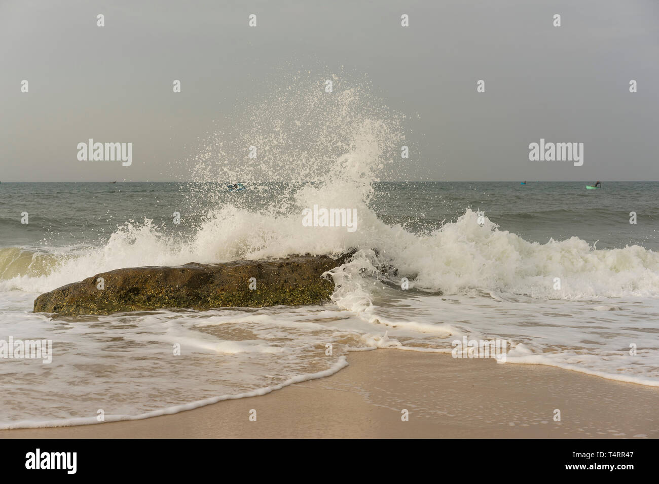 The waves breaking on a stony beach, forming a spray Stock Photo - Alamy