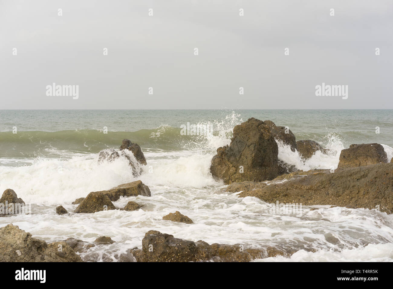 The waves breaking on a stony beach, forming a spray Stock Photo - Alamy