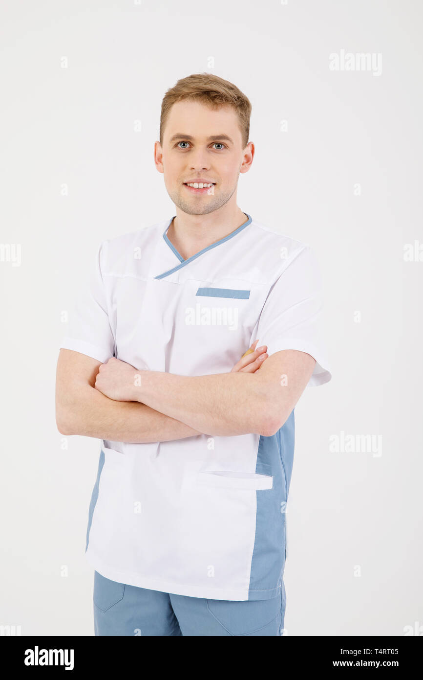 Young sympathetic doctor stands isolated on a white background dressed ...