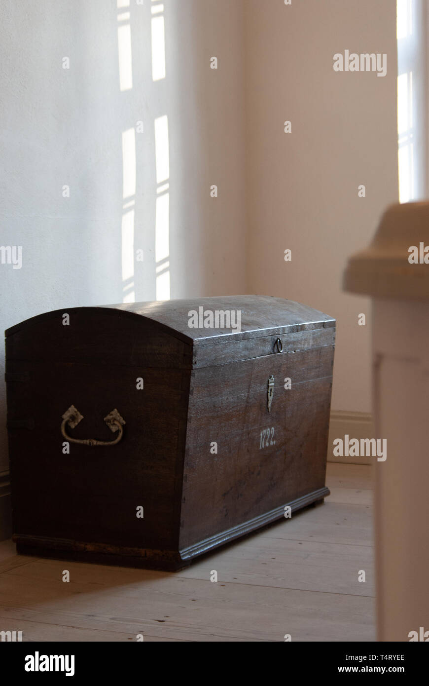 dark wooden chest on bright wooden floor in front of window Stock Photo ...
