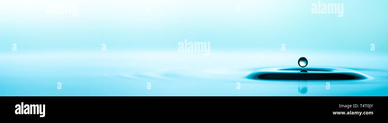 Clean Blue Water Droplet Splashing Into Puddle With Ripples Stock Photo ...