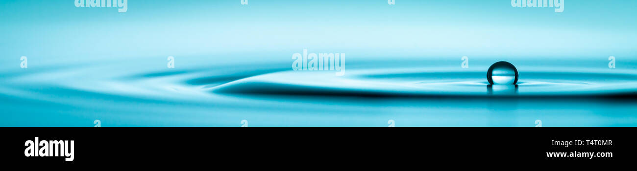 Clean Blue Water Droplet Splashing Into Puddle With Ripples Stock Photo ...