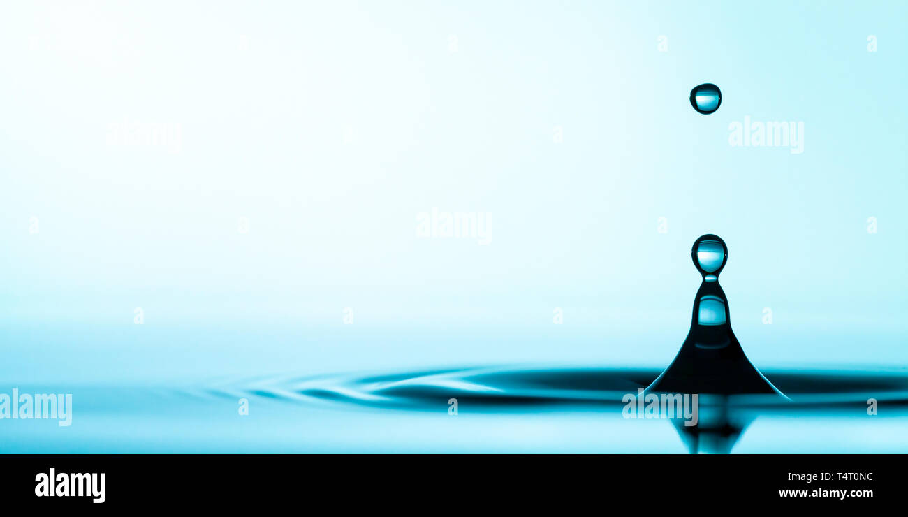 Clean Blue Water Droplet Splashing Into Puddle With Ripples Stock Photo ...
