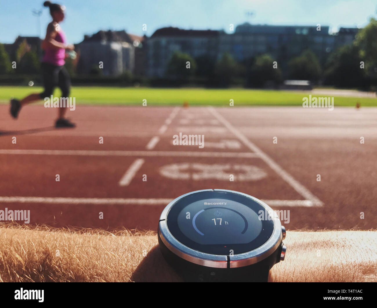 Trainer checking progress on smart watch. Female runner runnng on sport ...