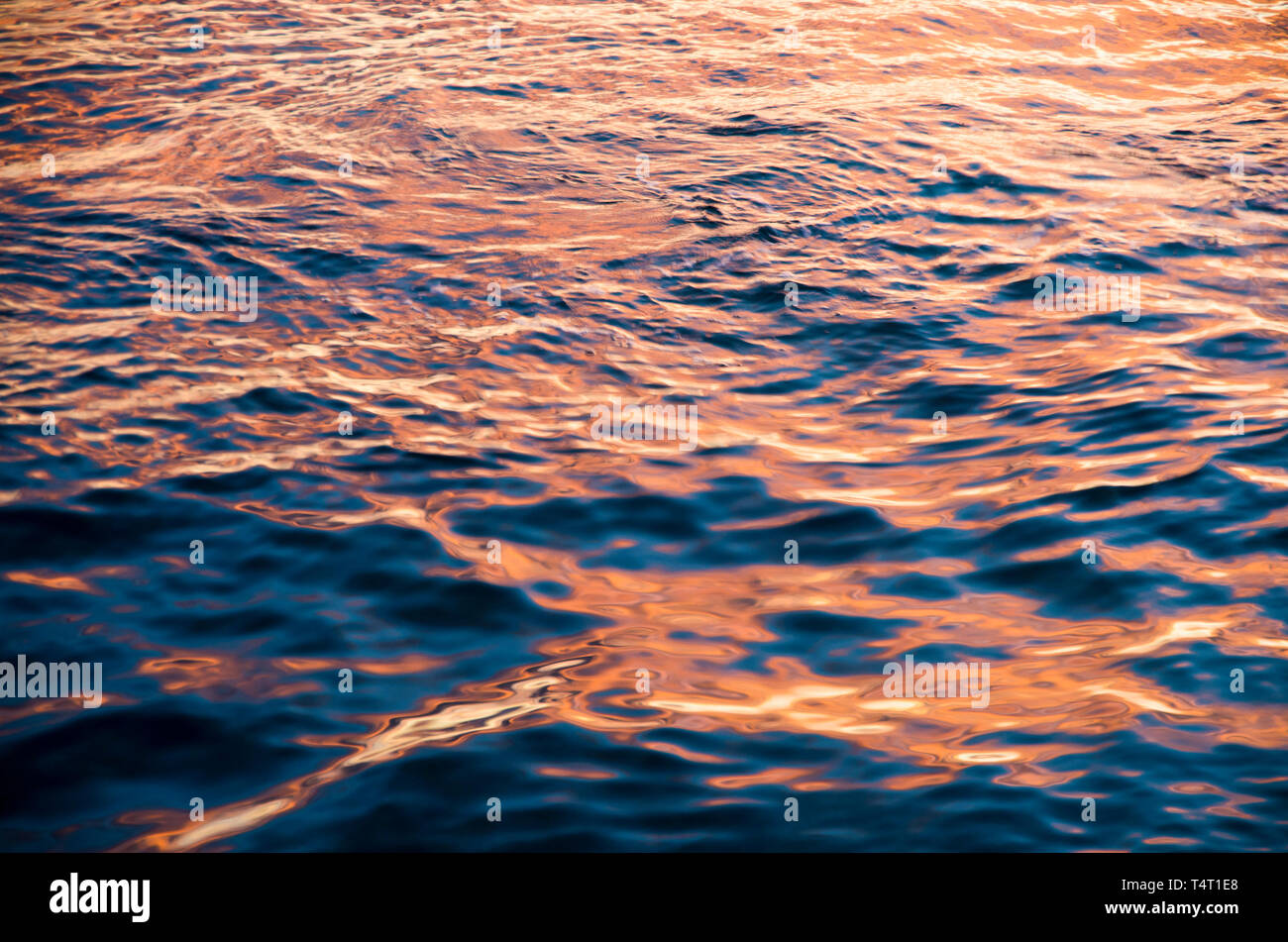 reflective water at sunset Stock Photo - Alamy