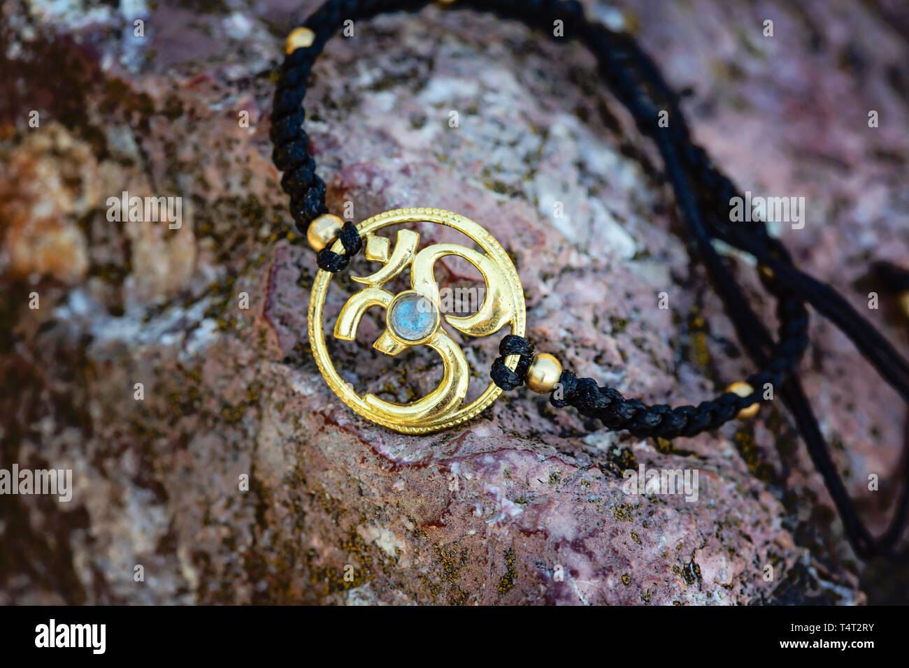 Metal om symbol macrame bracelet on natural rocky background Stock ...