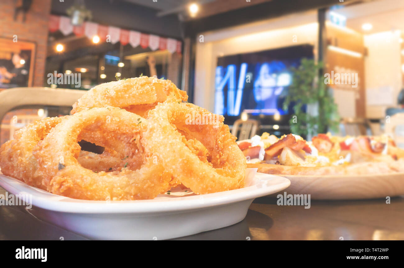 Deep fried onion ring serve along side with pizza Stock Photo - Alamy