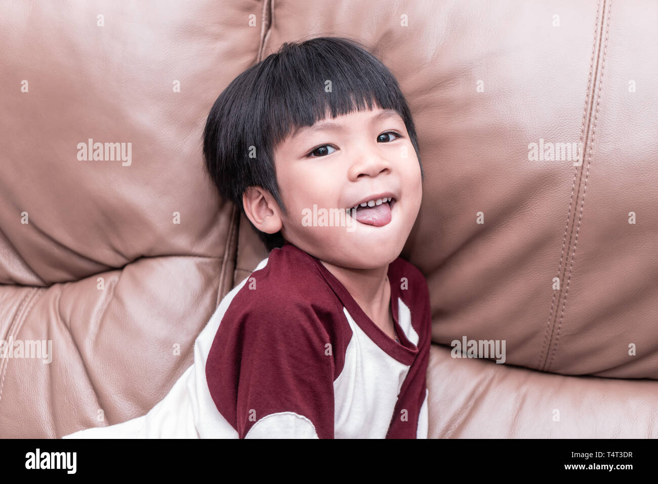 Little Asian Boy boy portrait front view on sofa Stock Photo - Alamy
