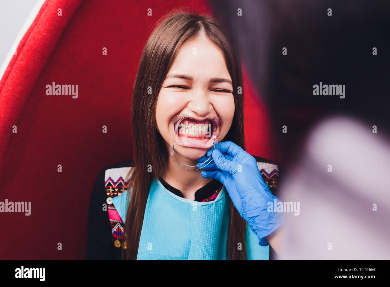 Close up of female mouth with retractor. Doctor flossing the teeth ...
