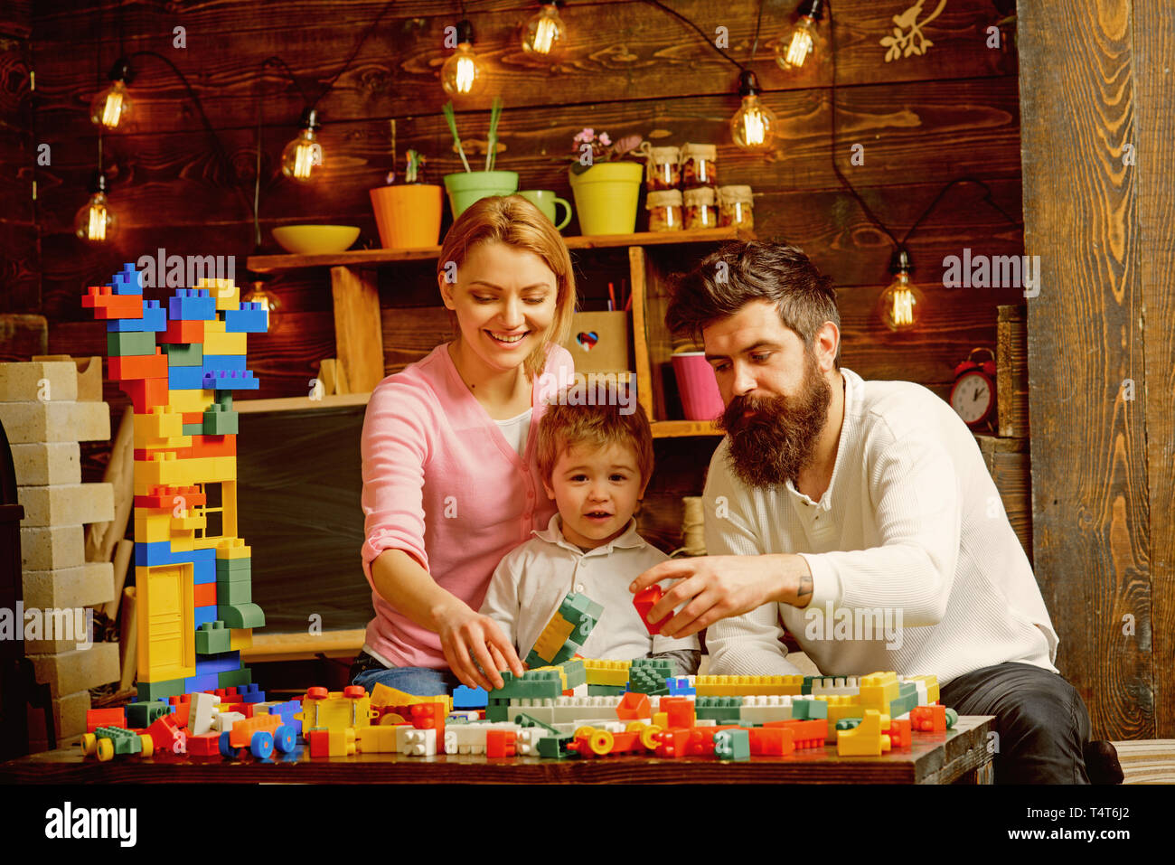 Cooperation concept. Family members cooperate in building structure ...