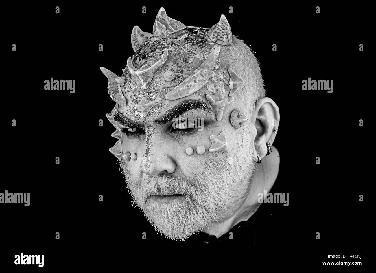 Head with thorns or warts, face covered with glitters, close up. Alien ...