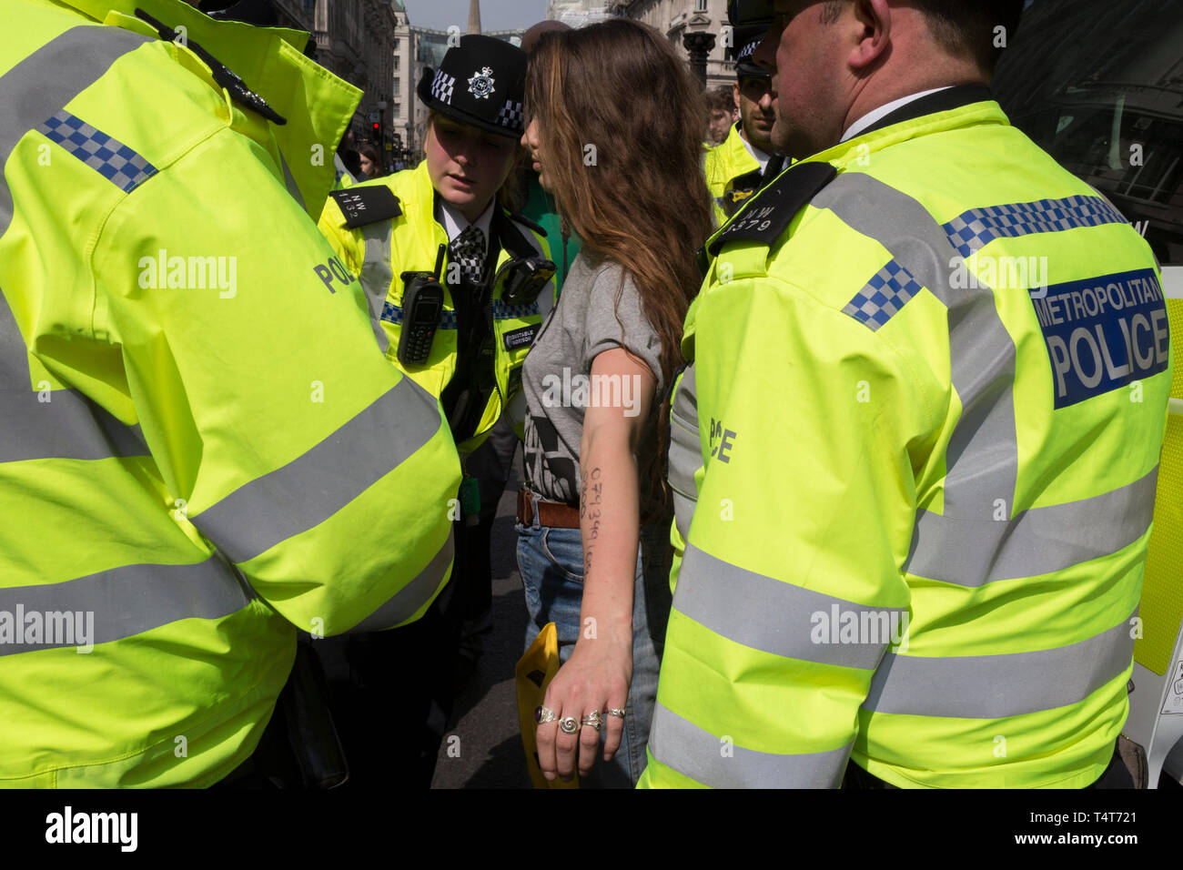 A young woman protester is arrested and searched by Met police officers ...