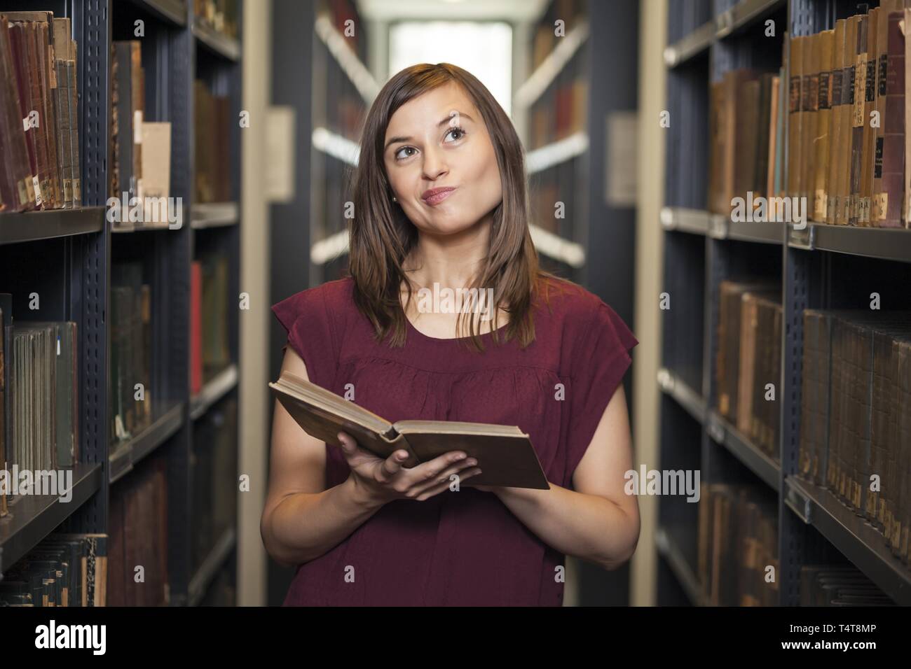 Student thinking in library Stock Photo - Alamy