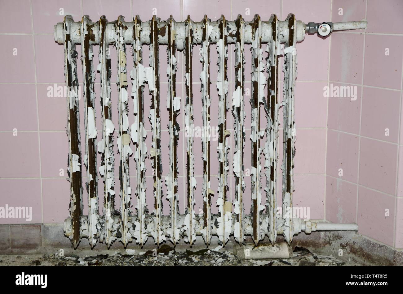 Old rusty radiator with pink tiles in background Stock Photo - Alamy