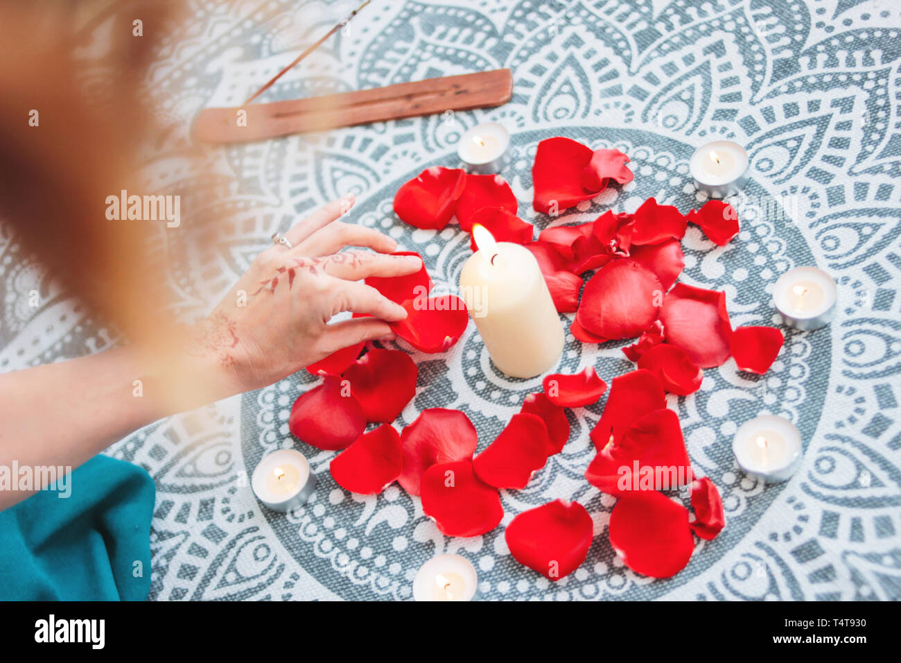 Dance of female hands with mehendi over the altar of candles and rose ...