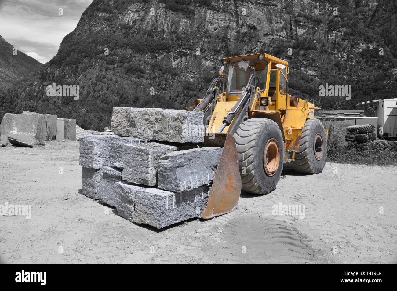 Yellow Digger with Stone Blocks Stock Photo - Alamy
