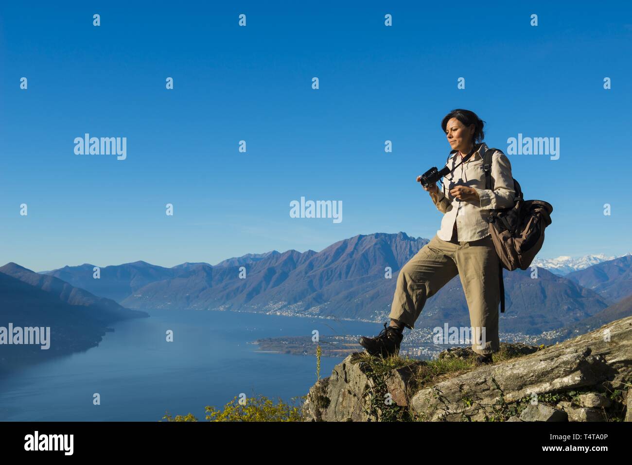 Hiker with photo camera, mountain overlook, Ticino, Switzerland Stock ...