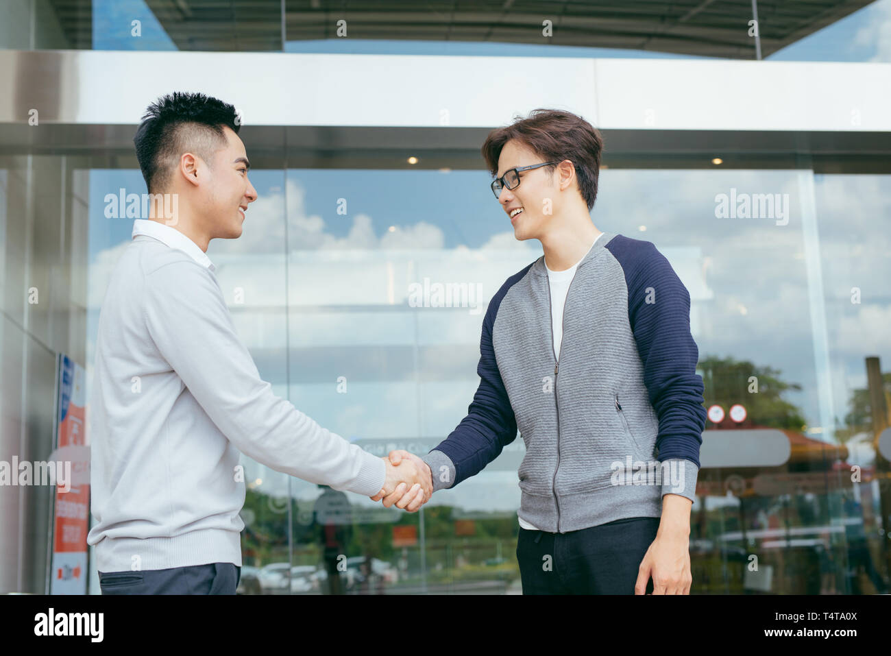 Two friends shaking hands smiling hi-res stock photography and images ...