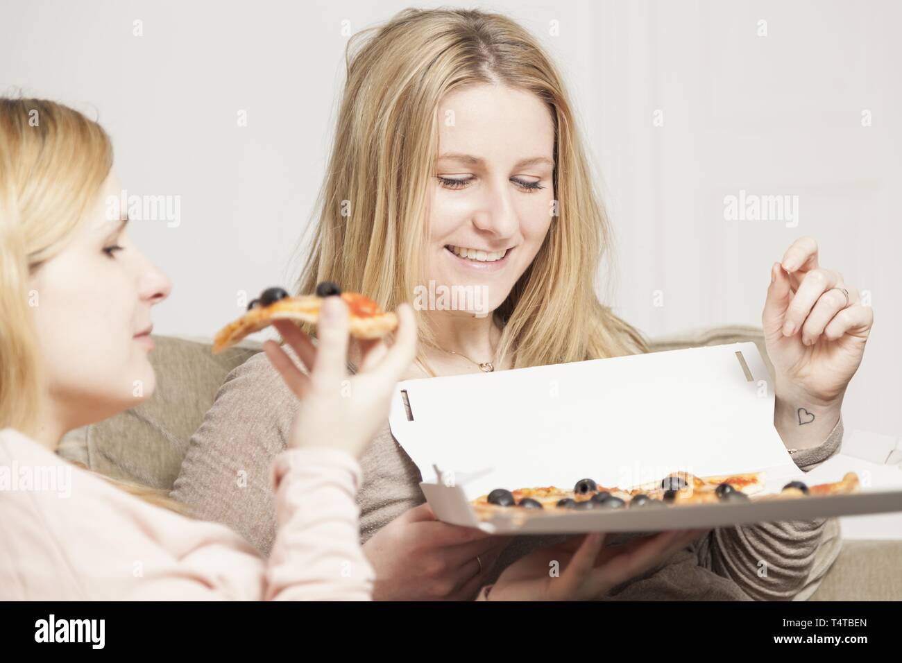 Two women eating pizza Stock Photo - Alamy