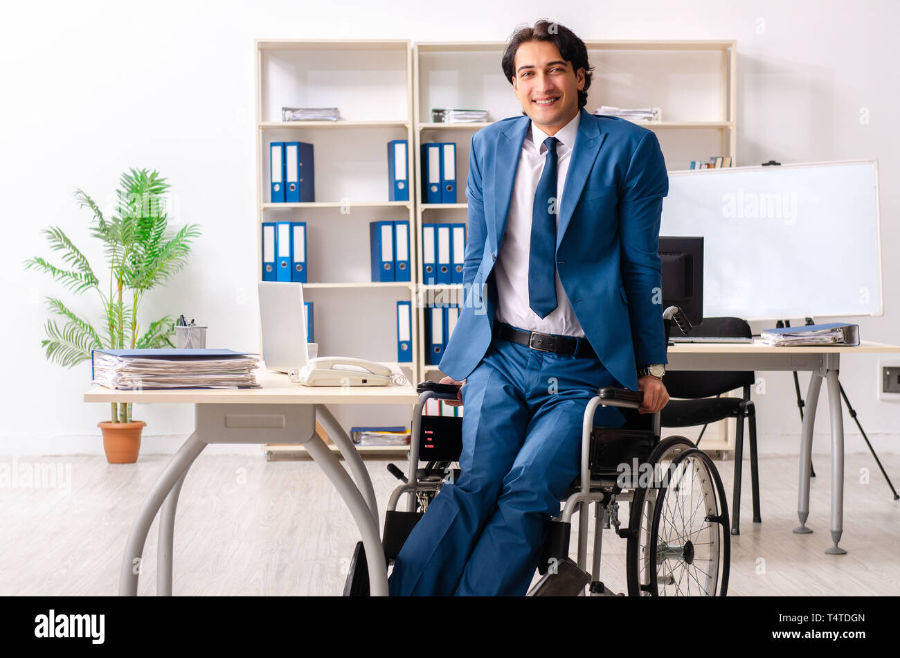 Male employee in wheelchair working at the office Stock Photo - Alamy