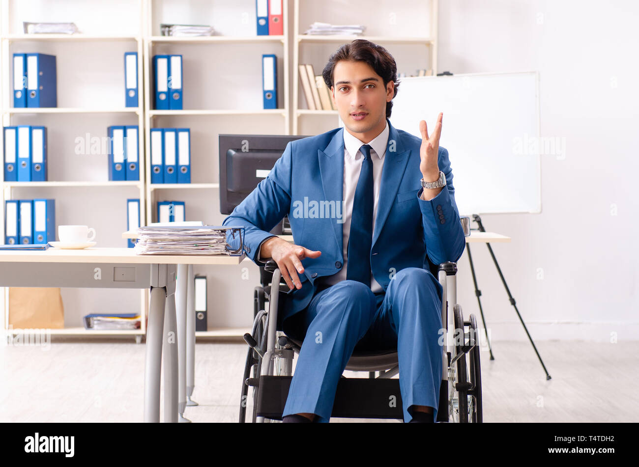 Male employee in wheelchair working at the office Stock Photo - Alamy