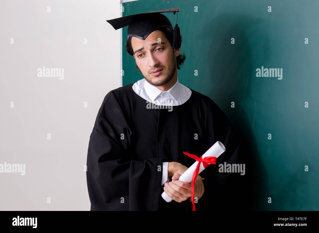 Graduate student in front of green board Stock Photo - Alamy