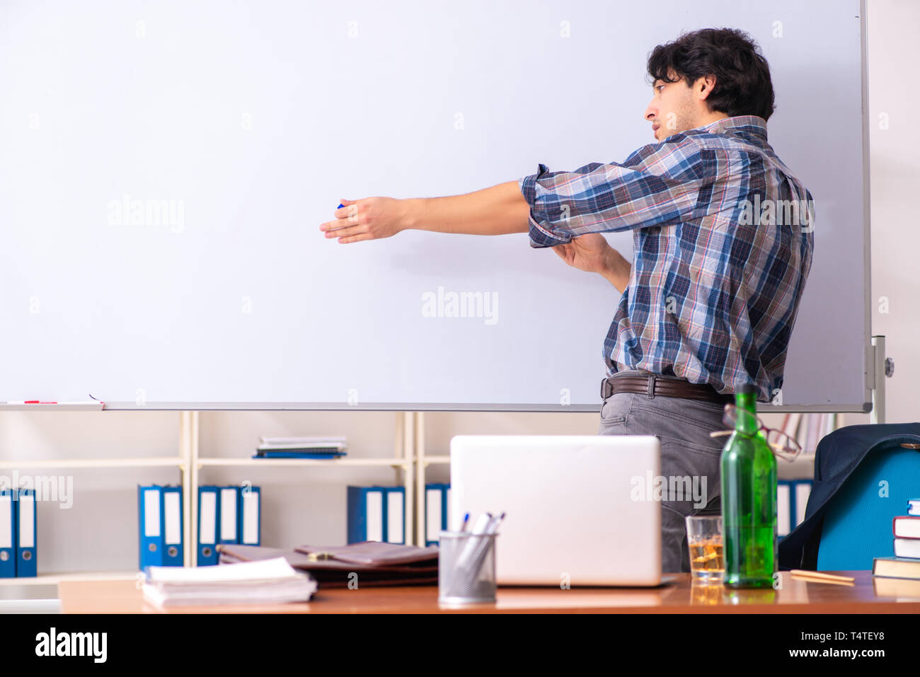Male teacher drinking in the classroom Stock Photo - Alamy