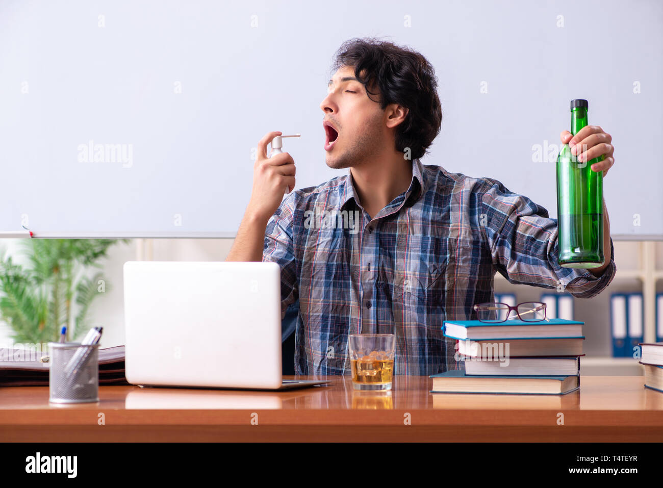 Male teacher drinking in the classroom Stock Photo - Alamy