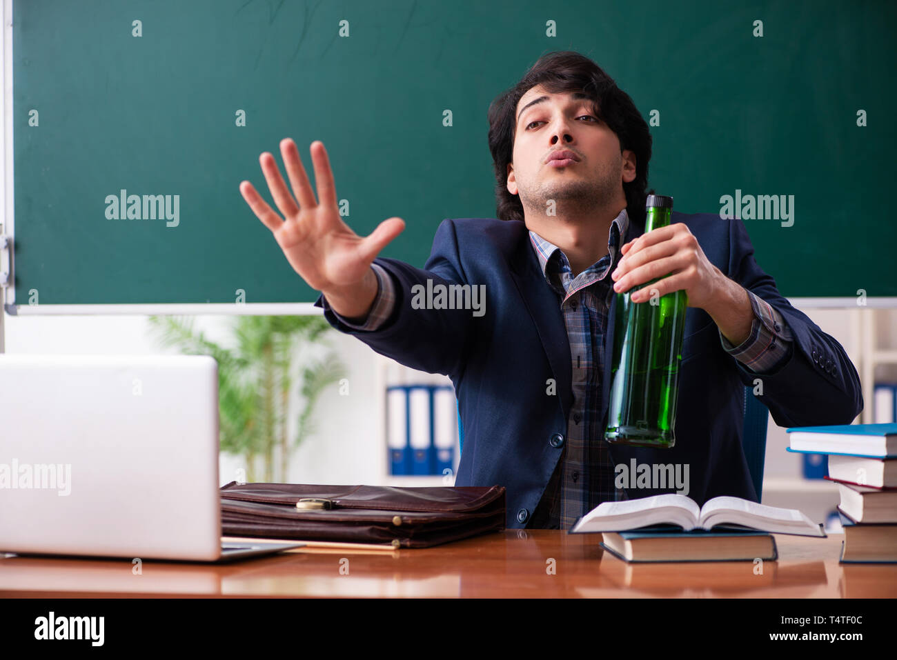 Male teacher drinking in the classroom Stock Photo - Alamy