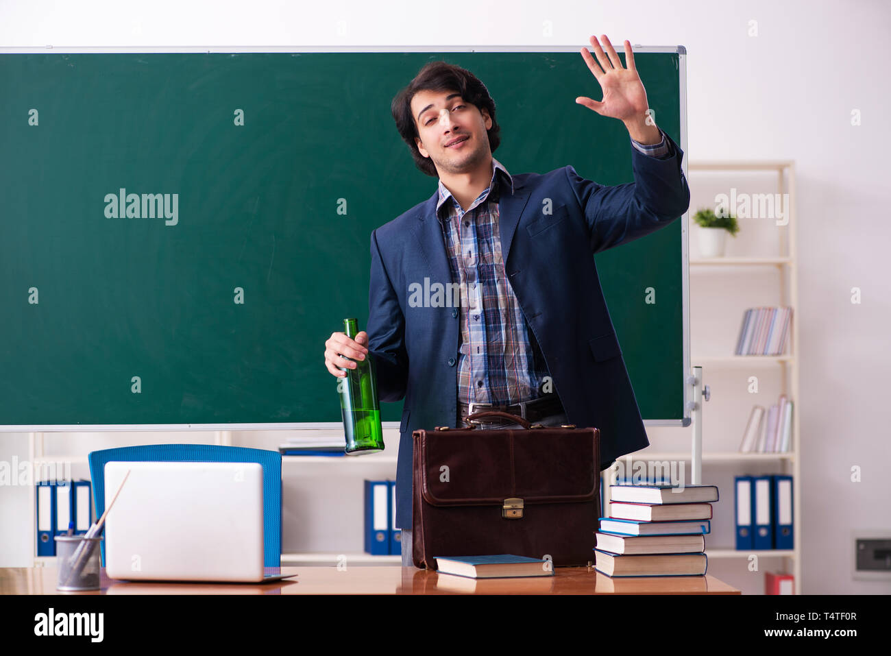 Male teacher drinking in the classroom Stock Photo - Alamy