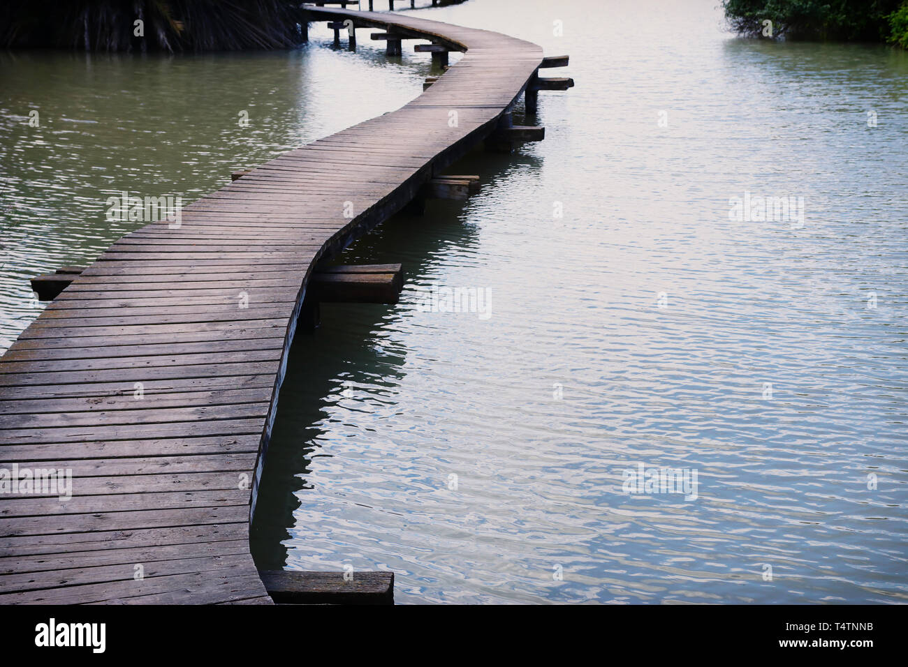 Old wooden path or bridge over river Stock Photo - Alamy